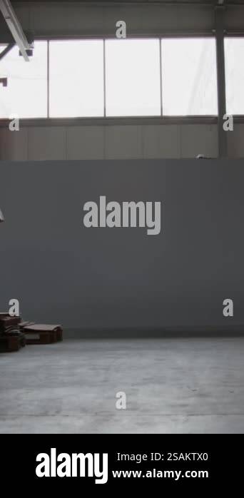 Full vertical lockdown shot of male warehouse porter in uniform, yellow ...