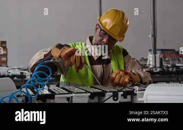 Medium portrait of busy mature Asian male specialist in hardhat working ...