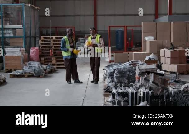 Wide shot of multiethnic male warehouse employees, Asian manager and ...