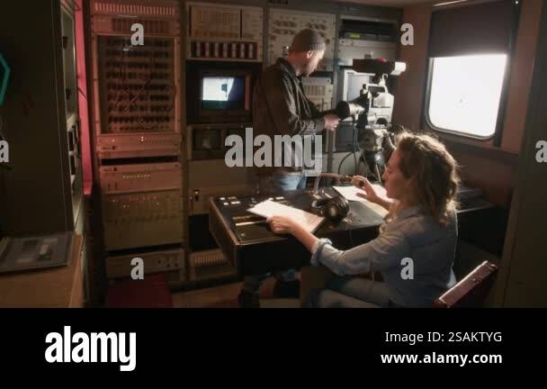 Medium full shot of young Caucasian female reporter sitting in TV ...