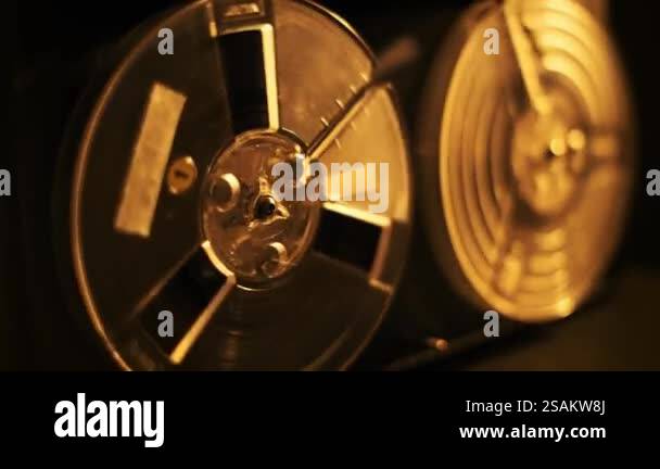 A close-up view of a vintage reel-to-reel tape player with rotating ...