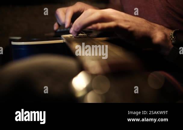 Focused, medium close-up of a guitar player fingers precisely pressing ...