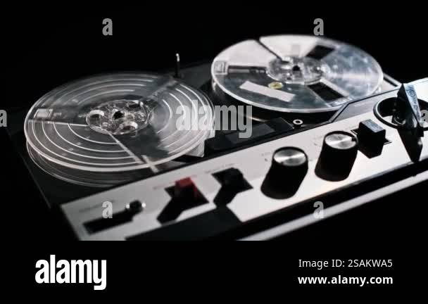 This footage showcases a vintage reel-to-reel tape recorder, with focus ...