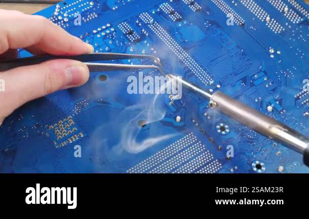 Repair the motherboard in the workshop. Hands of the master, close-up ...