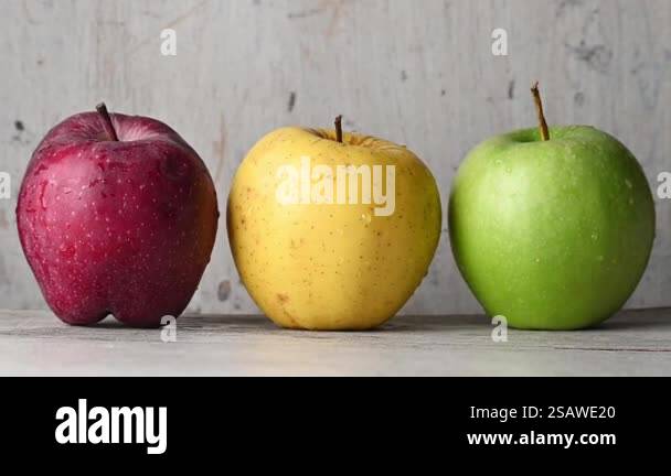 Three apples of different varieties and colors: red, yellow, green ...