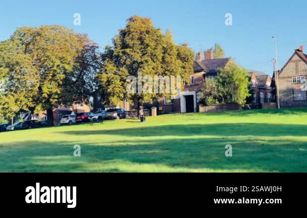 English village green surrounded by historic stone cottages and leafy ...