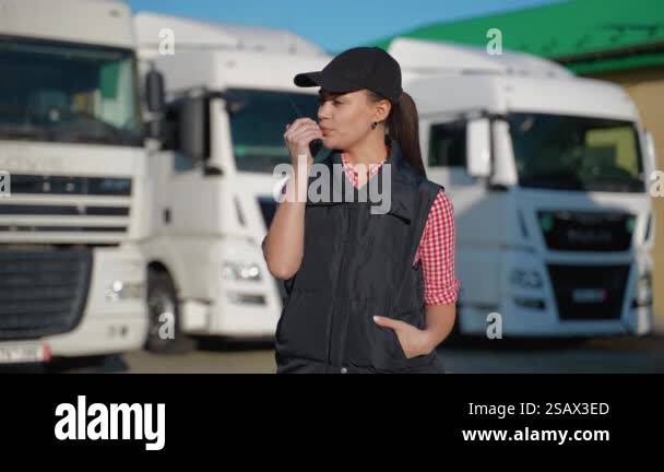 A female supervisor in uniform communicates through a walkie-talkie ...