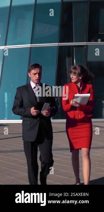 Slow motion: Business couple male and female walking near business ...