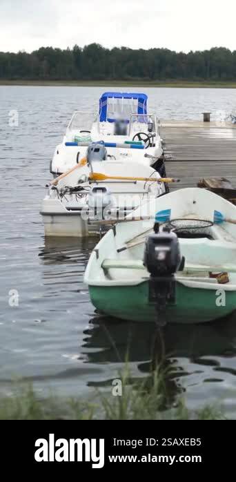 A pier with small boats is seen in the fishing village with motor and ...