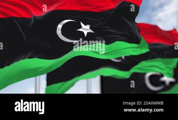 National flags of Libya waving on a clear day. Red, black, green ...