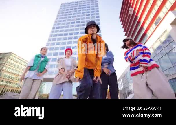 Energetic Breakdancer Showcasing a Skillful Freeze Move while Friends ...