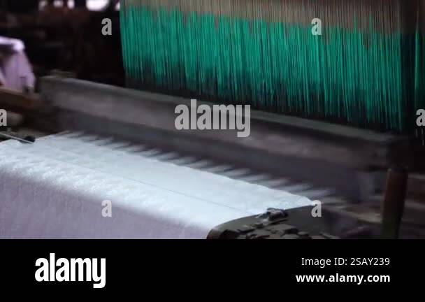 Working spin machine in a cloth silk factory, close up. Factory for the ...