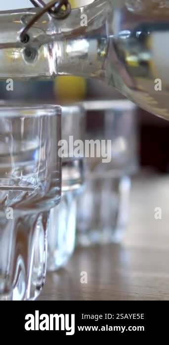 Pouring Cold Water into a Glass. Hands gracefully pour cold water from ...