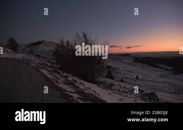 Beautiful sunset over the snowy mountains. Handy tracking shot of a ...
