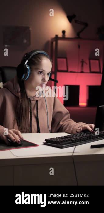 Sad Gamer wearing headphones playing shooter video game on pc at home ...