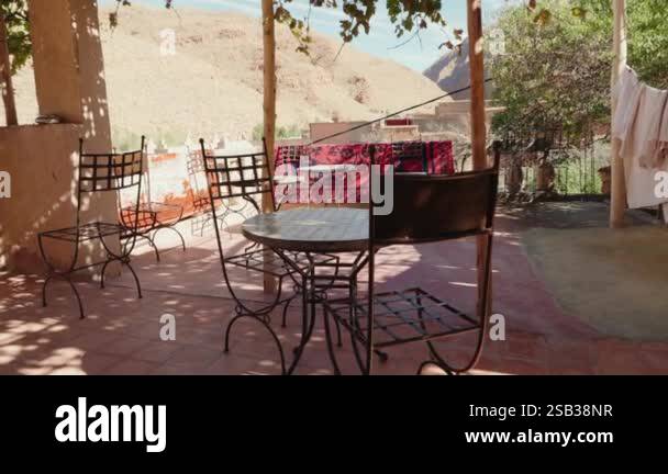 Tranquil Moroccan rooftop patio with metal table and chairs under a ...