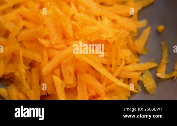 Thin orange strips of grated butternut squash. Organic shredded ...