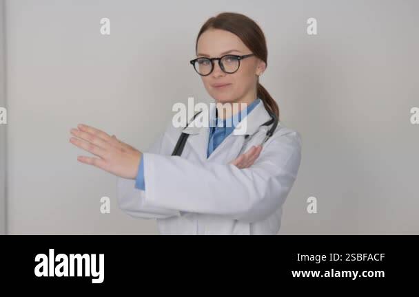 A confident female physician in stylish glasses and a white lab coat ...