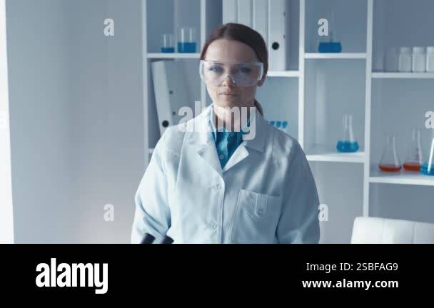 A determined female scientist stands confidently in a sleek laboratory ...