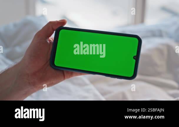 Man hand scrolling mockup cellphone in bed choosing online purchases at ...