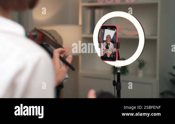 Back view influencer shoot live with smartphpone streaming using vlog ...