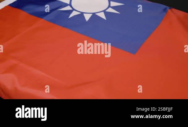 This video closely examines a vibrant red, blue, and white flag with a ...