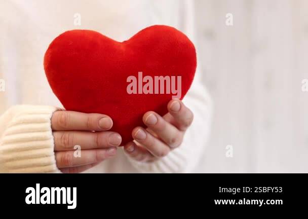 Toy heart in girl's hands. Plush soft heart in woman's hands, close-up ...