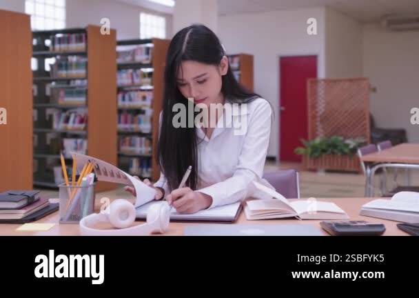 Young Asian female university students are actively reading books to study, research, and ...