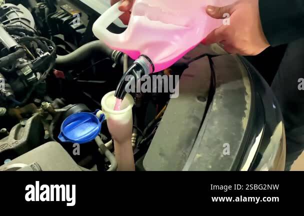 Driver mechanic pouring antifreeze,non freezing liquid car windshield ...