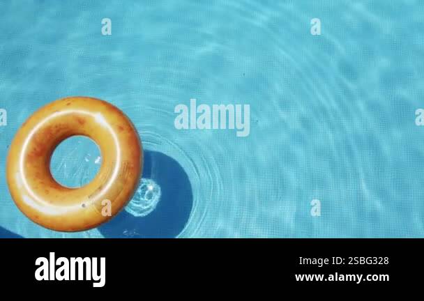 Yellow swim ring or swim tube floating over transparent water of the ...