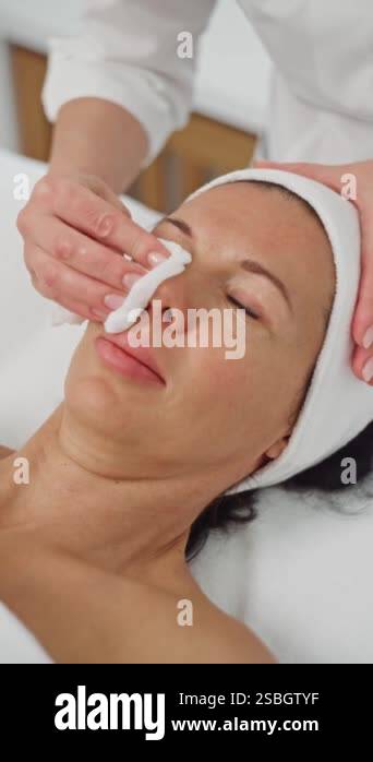 Cosmetologist washing a womanface before applying cream and anesthesia ...