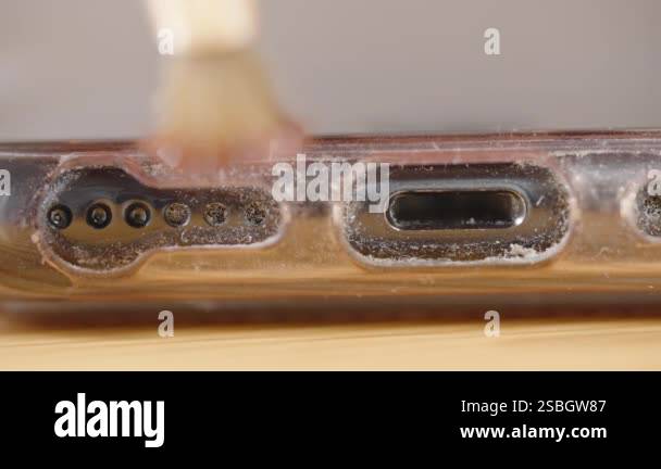 A close-up of the smartphone's charging port and speaker holes, covered ...
