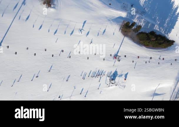 Aerial view of ski slope with skiers and lifts, ski tracks on snow and ...