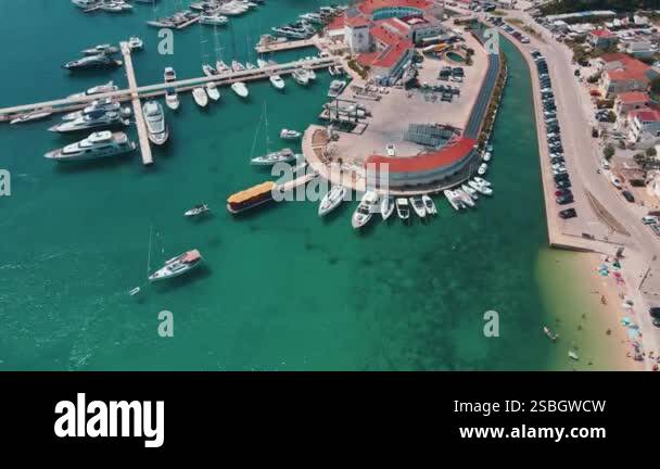 Aerial view of coastal marina with boats docked along turquoise waters ...