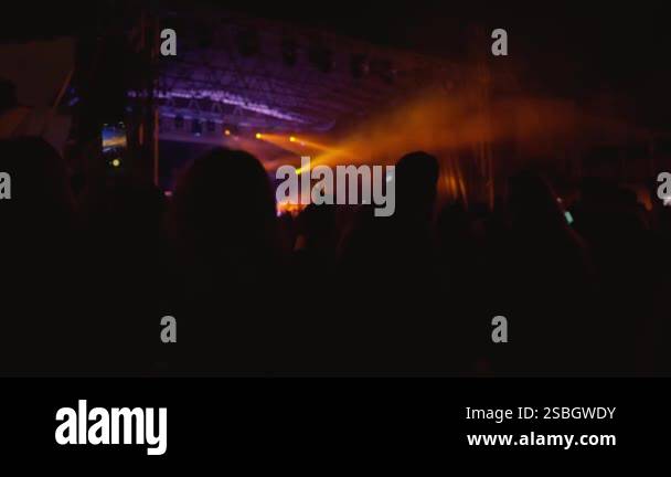 Vibrant live concert scene with band performing on stage under bright ...