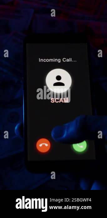 Vertical video. A smartphone shows an incoming scam call alert while ...