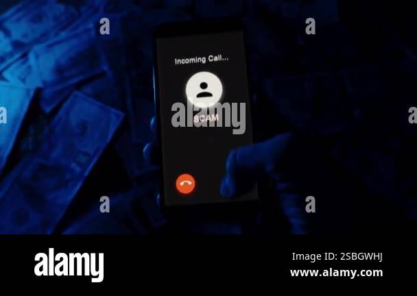 A hand holds a smartphone displaying an incoming scam call alert, with ...