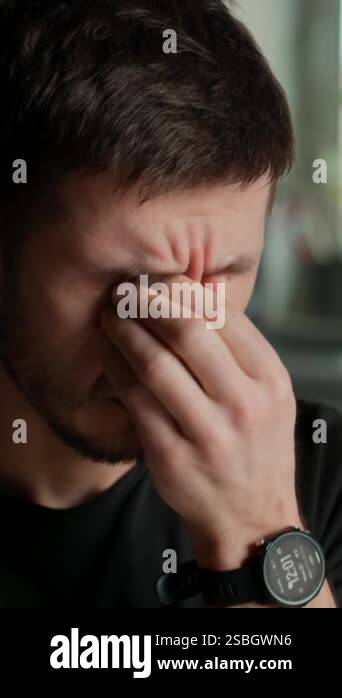 Tired man rubbing his eyes and pinching bridge of his nose. Close up of ...