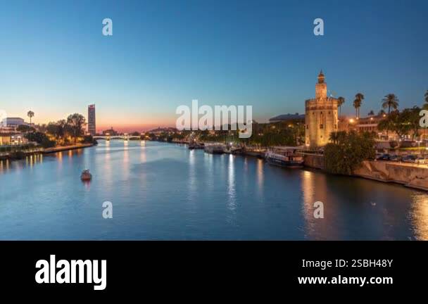 Tour boat floating along the Guadalquivir River near Torre del Oro ...