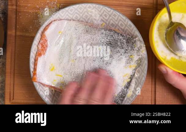 The process of salting salmon fish. The pieces of fish are sprinkled ...