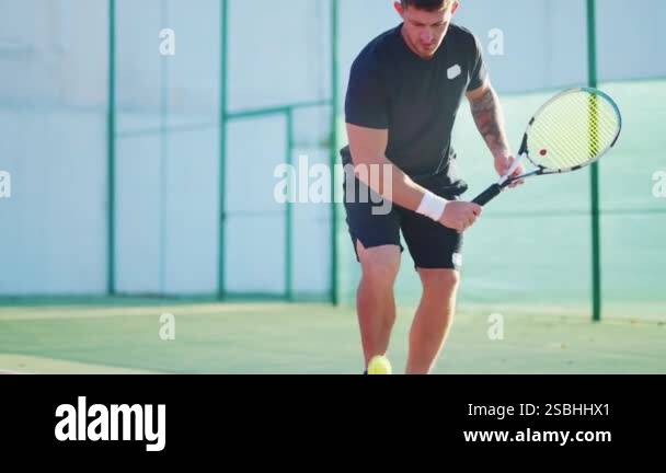 Man playing tennis game on court. Guy shots the ball practicing ...