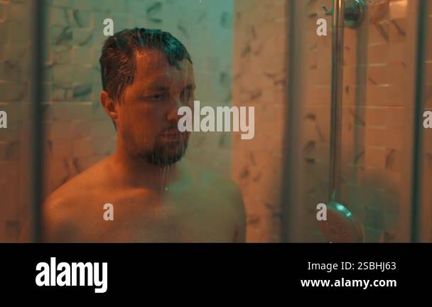frustrated man standing in shower in night, depression and hard working ...