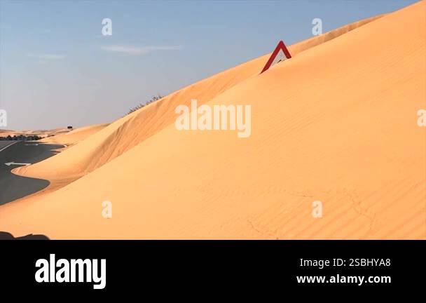 Road sign partially obscured by shifting desert sand, symbolizing ...