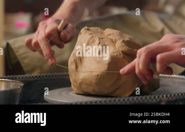 Hands master man cutting piece raw clay thread string potter ...