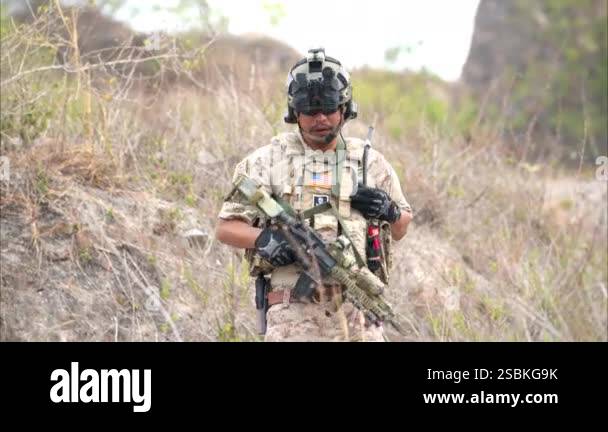 Soldiers in camouflage military uniforms carrying weapons ...