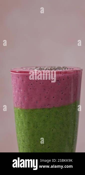 green and pink colored smoothie with chia seeds glass is spinning ...