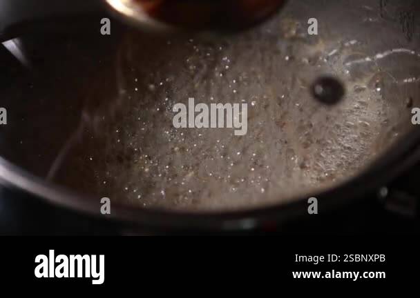 Close-up shot of cooking quinoa in a small pot, showing the grains ...