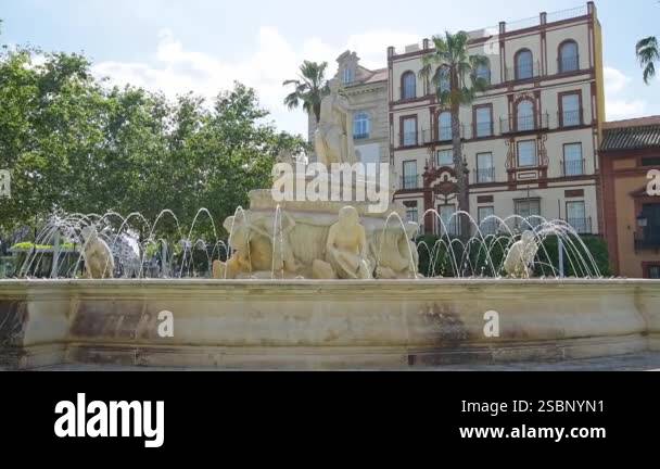 A detailed fountain in Seville features stone sculptures, water streams ...