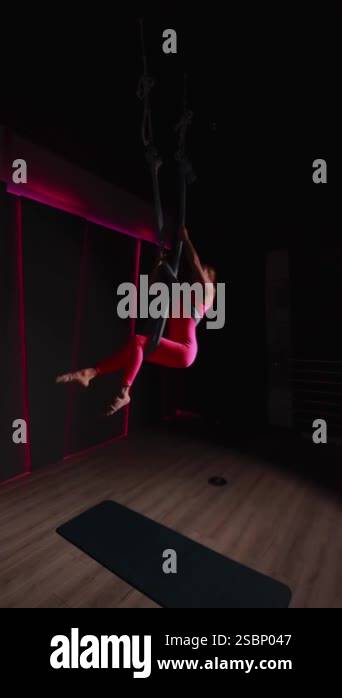 Aerial silks performer executing complex acrobatic dance, hanging ...