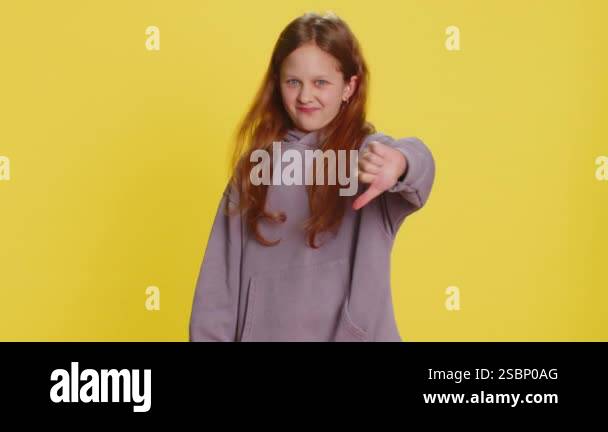 Dislike. Upset young preteen child girl kid showing thumbs down sign ...